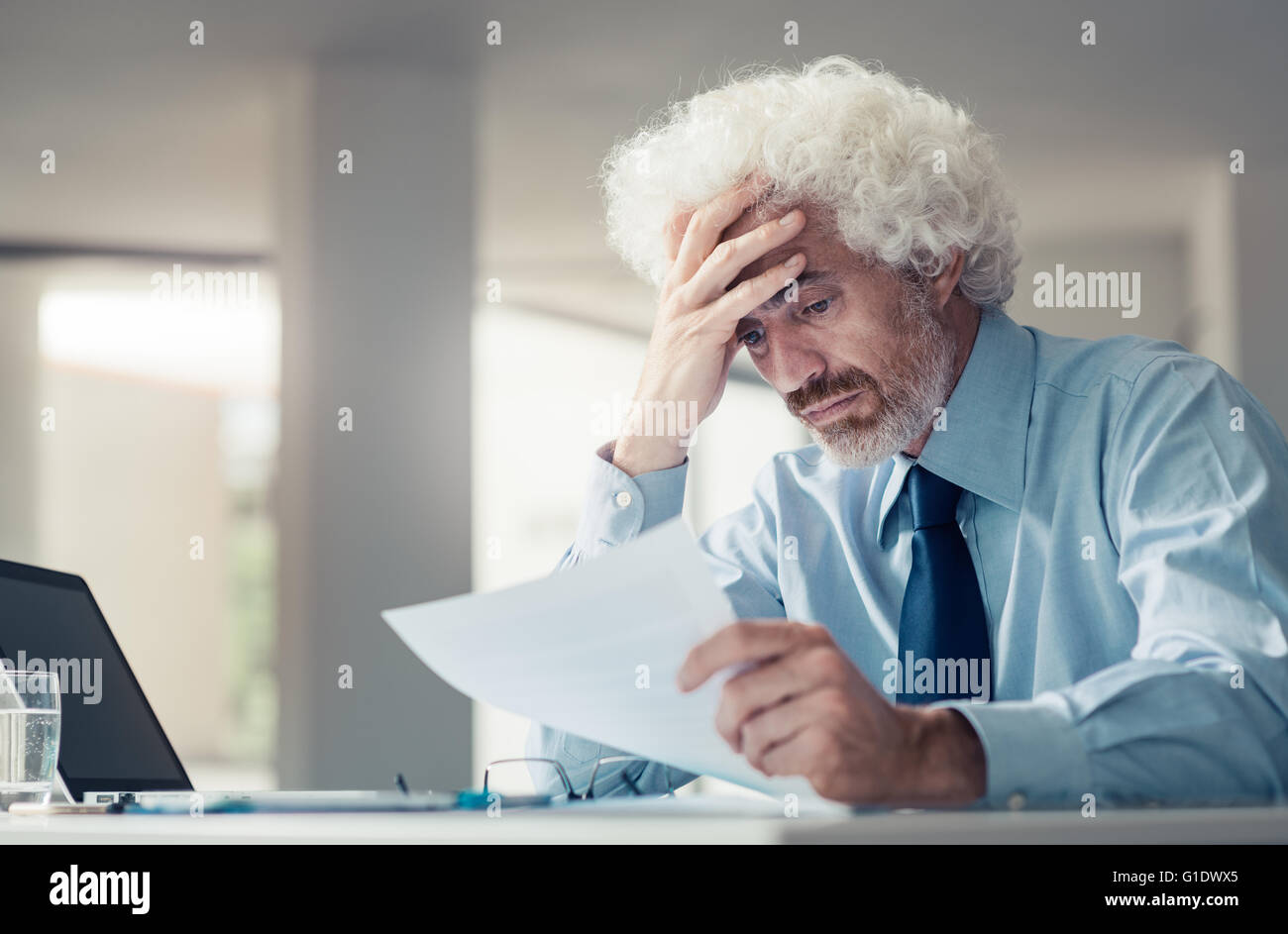 Confused shocked businessman receiving bad news, reading a letter and ...