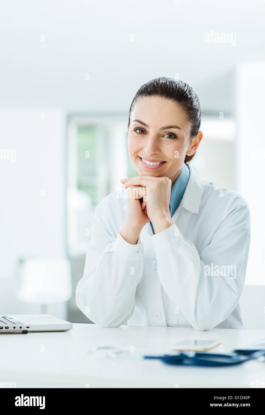 Beautiful female doctor posing and smiling at camera, health care and ...