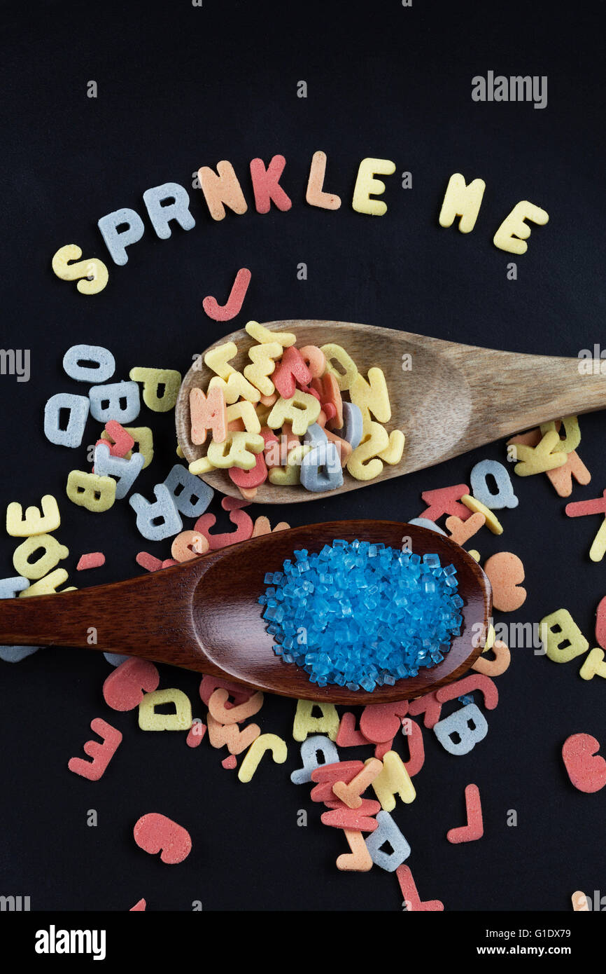 Colorful sugar lettered sprinkles in wooden spoons. Vertical image ...