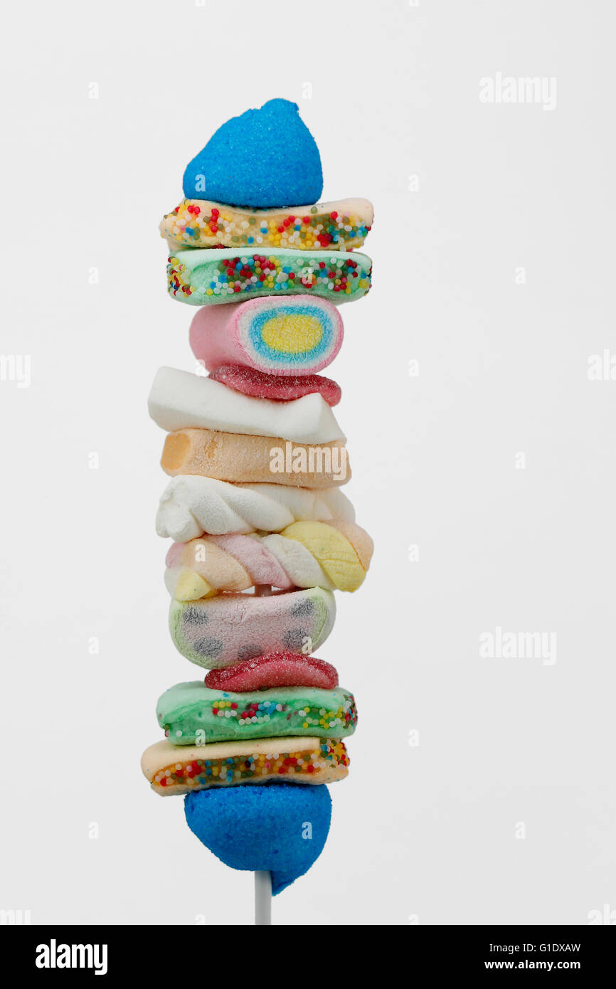 Brochette of sweet candies, in a white background Stock Photo - Alamy