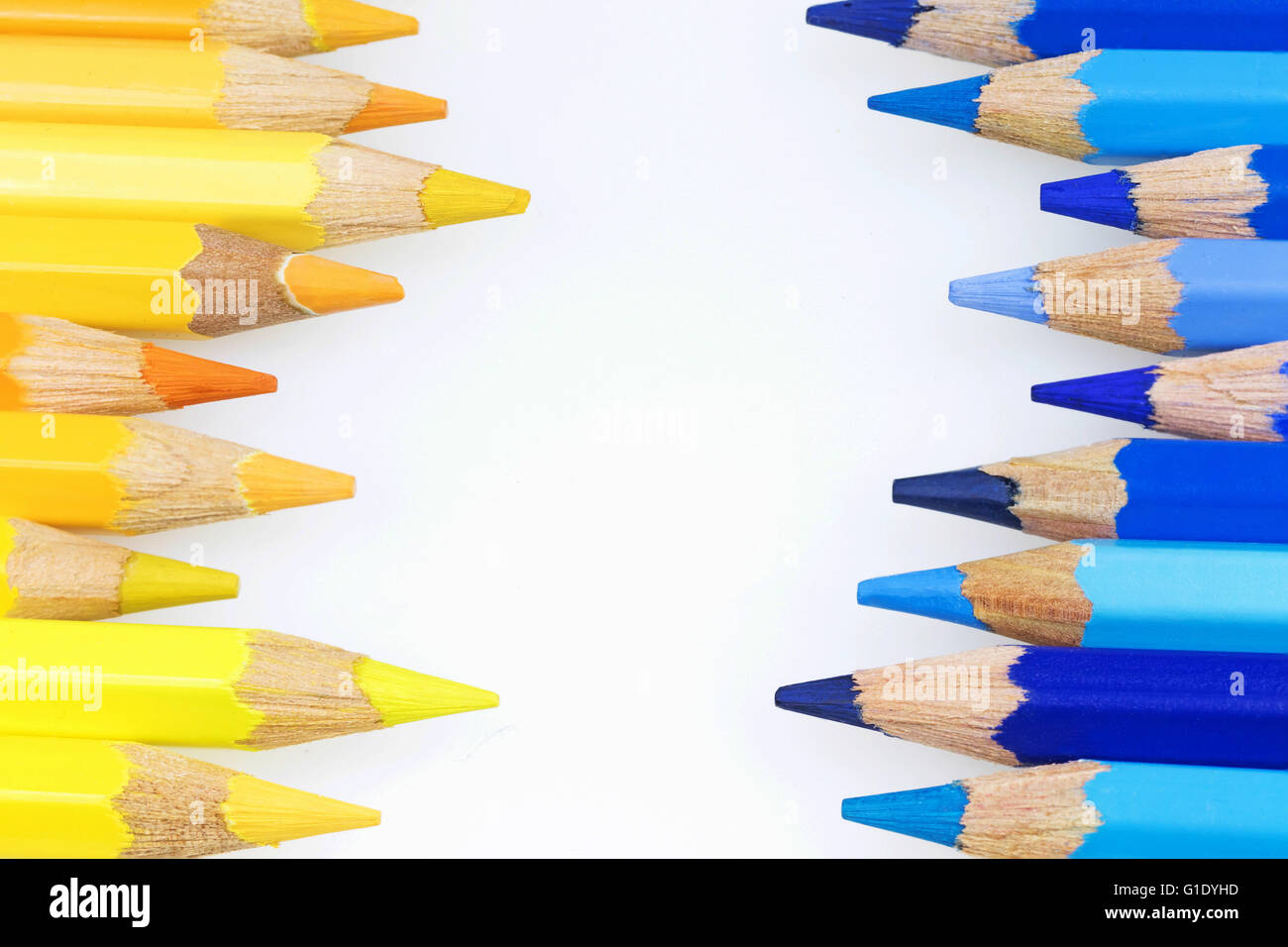 Crayons of different shades of blue and yellow color with copy space ...