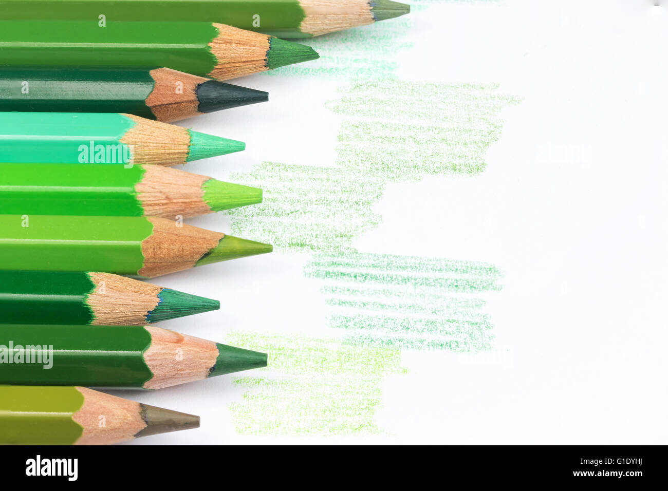 Crayons of different shades of green color are located on the left side ...