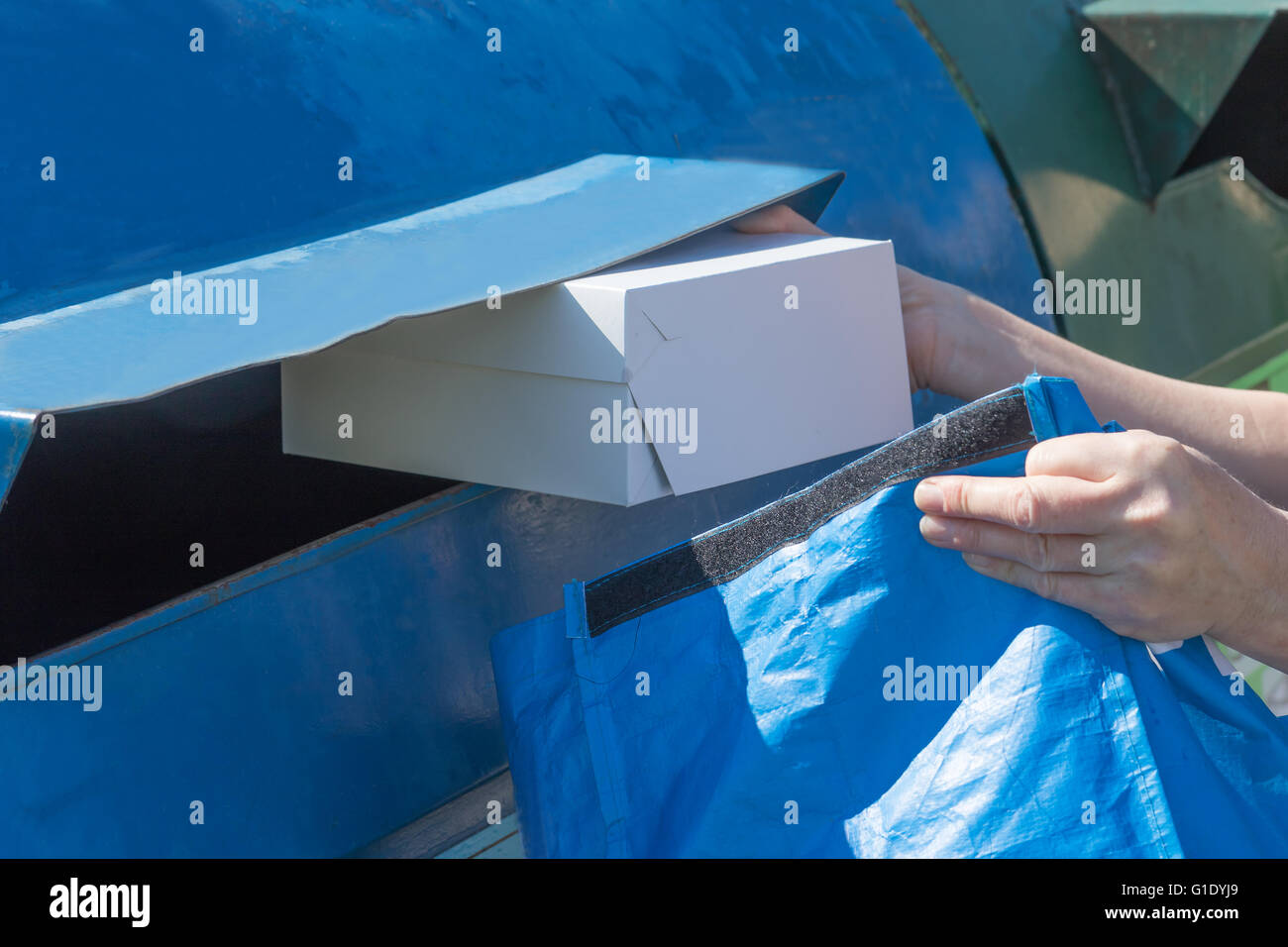 The woman is throwing a paper box from blue portable bag to blue ...