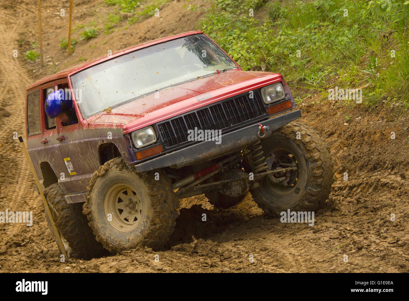 Unidentified racer at red Jeep off-road car on a steep slope in the ...