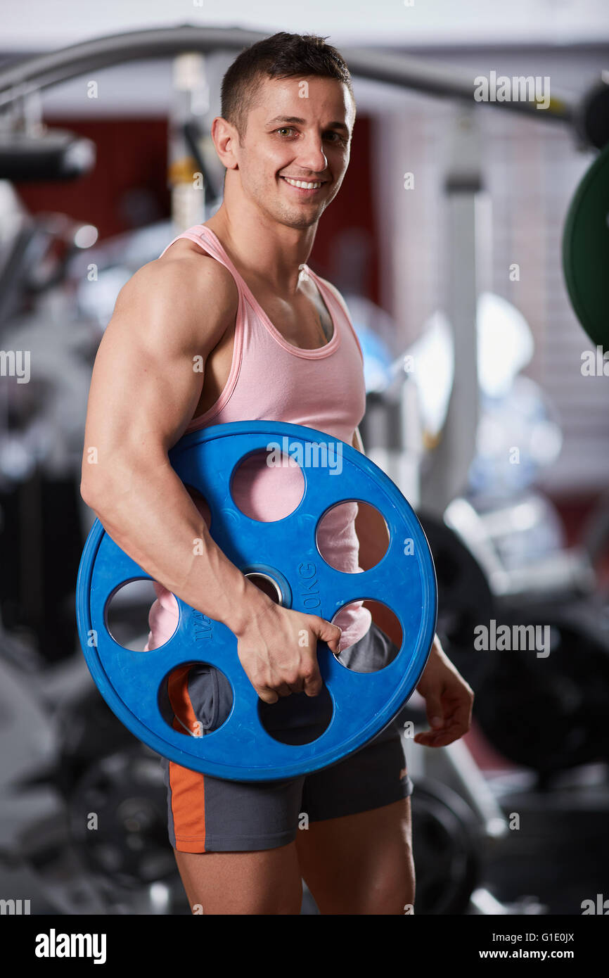 Male fitness model posing holding weights in the gym Stock Photo - Alamy