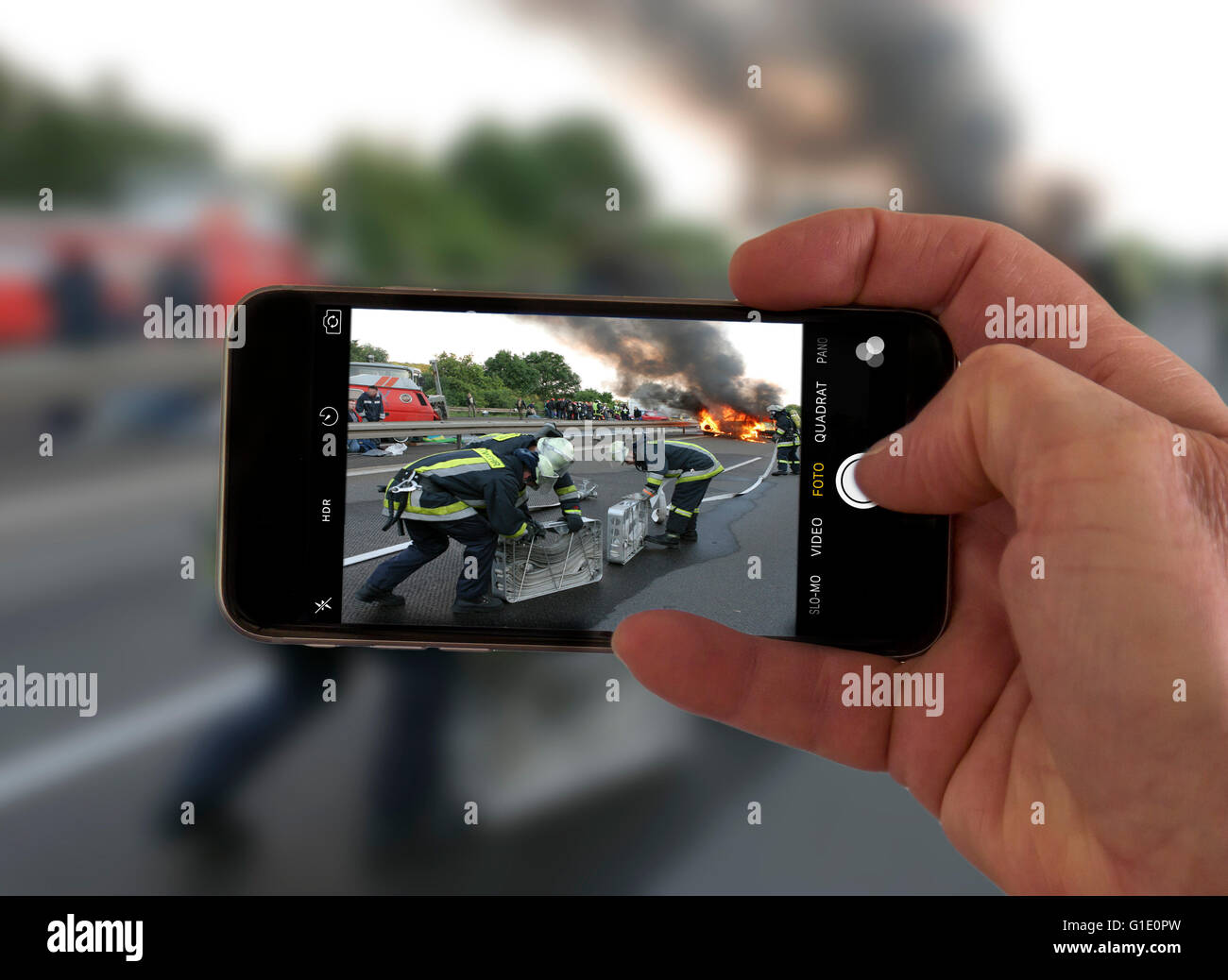Onlookers take picture with a mobile phone camera, of an accident ...