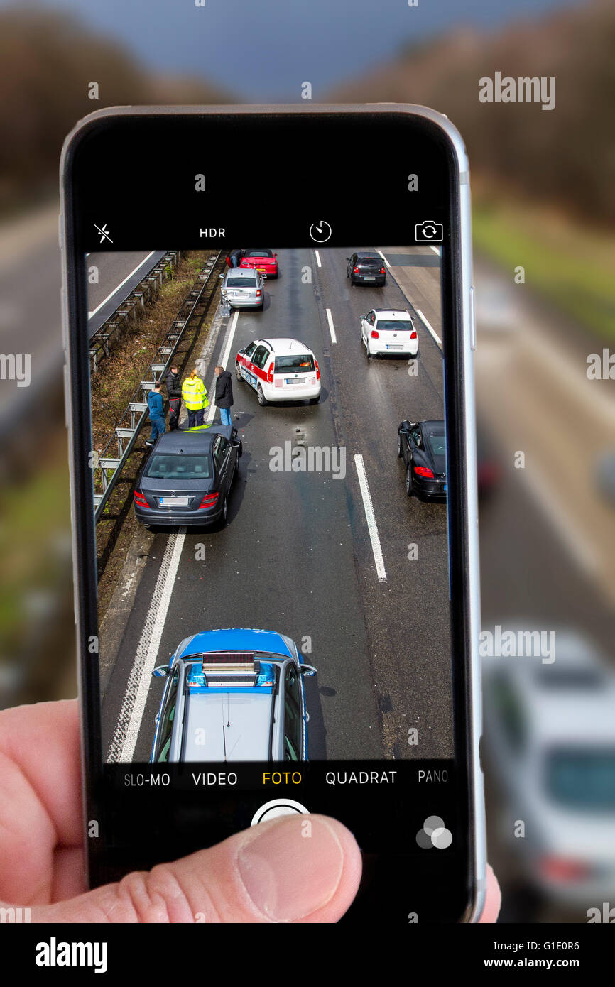 Onlookers take picture with a mobile phone camera, of an accident ...