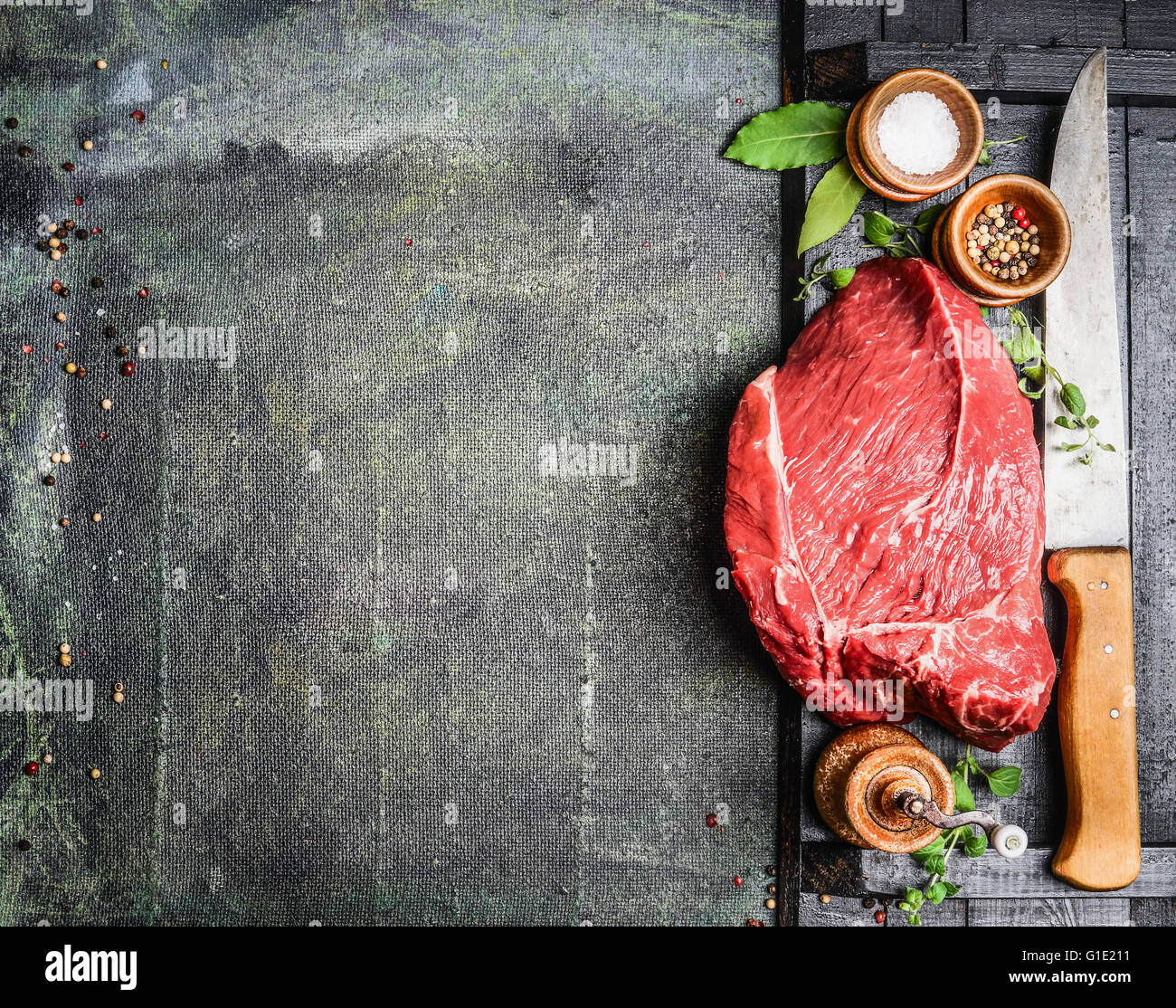 Fresh raw meat with herbs,spices and butcher knife on rustic background ...