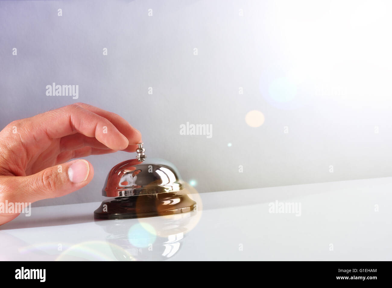 Hand of a Customer ringing the bell hotel service on a table white ...
