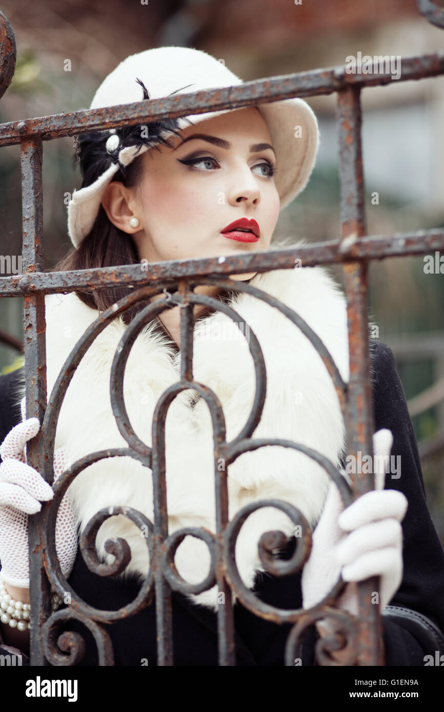 Woman in vintage clothes standing behind the gates Stock Photo - Alamy