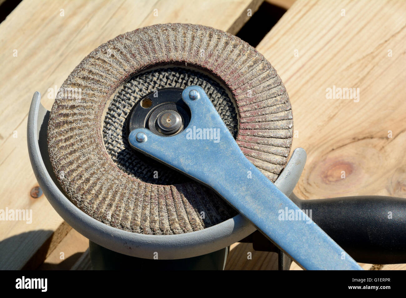 Front part of angle grinder with abrasive disc and spanner after work ...
