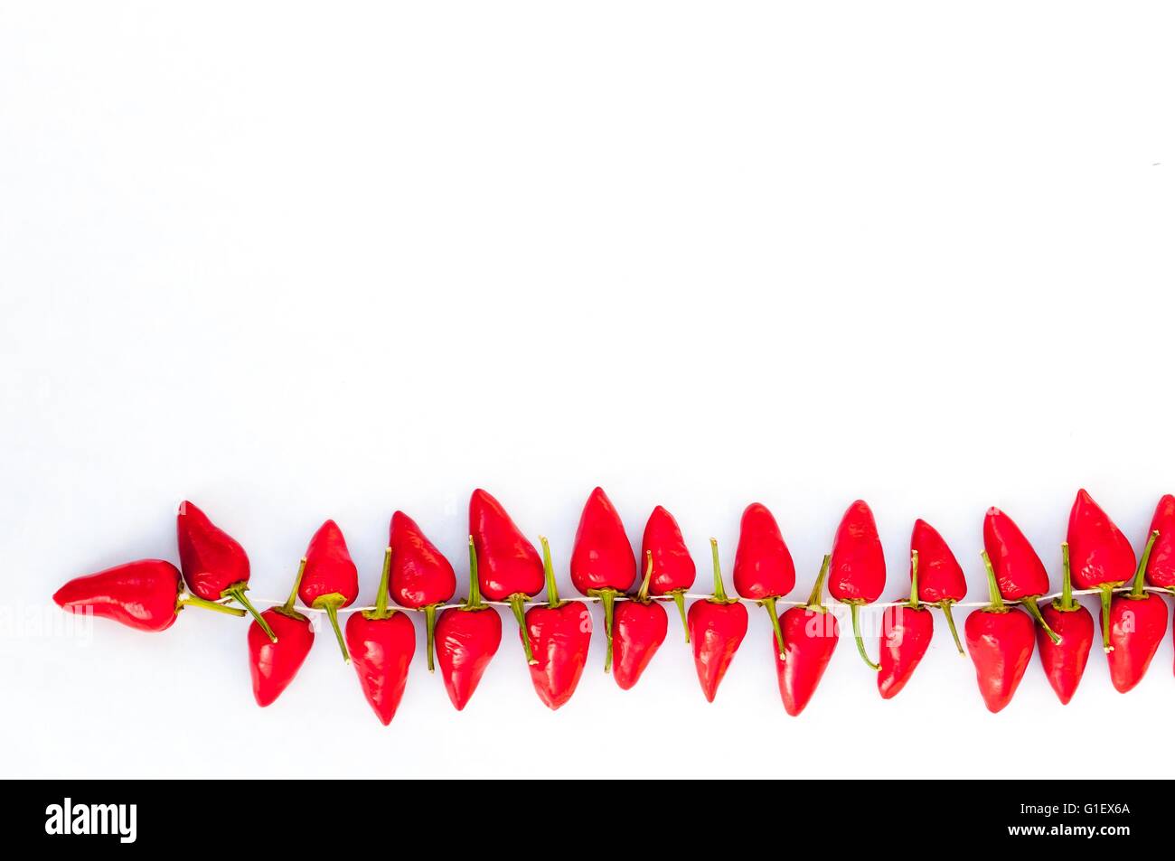 Group of fresh red hot chilli peppers on the bottom of white background ...