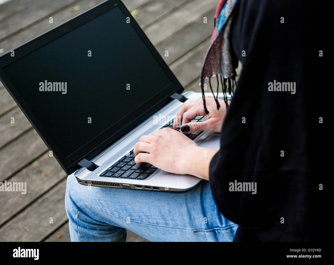 Side view of woman's hands writing on laptop Stock Photo - Alamy