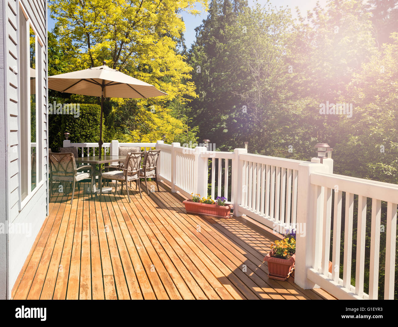 Afternoon bright daylight on outdoor home cedar deck with furniture and ...
