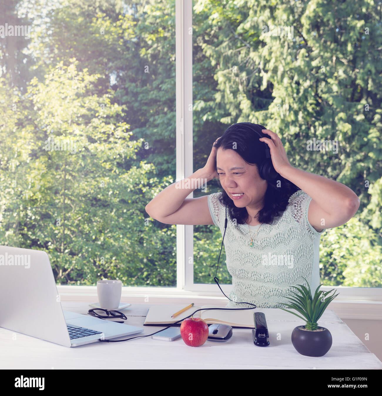 Angry mature woman working at home during morning light. Light effect ...