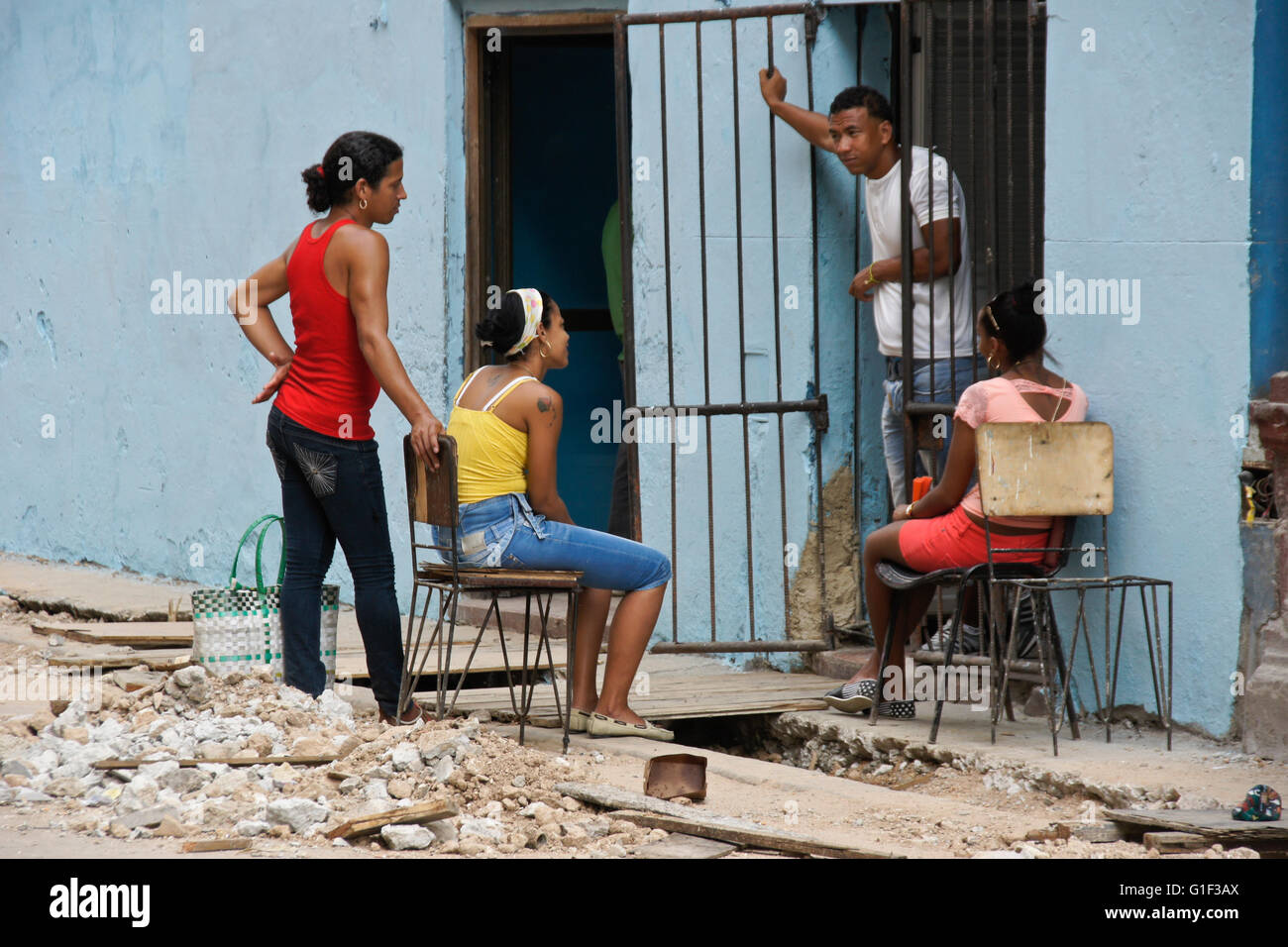 People socializing outside their house, among street rubble, Havana ...