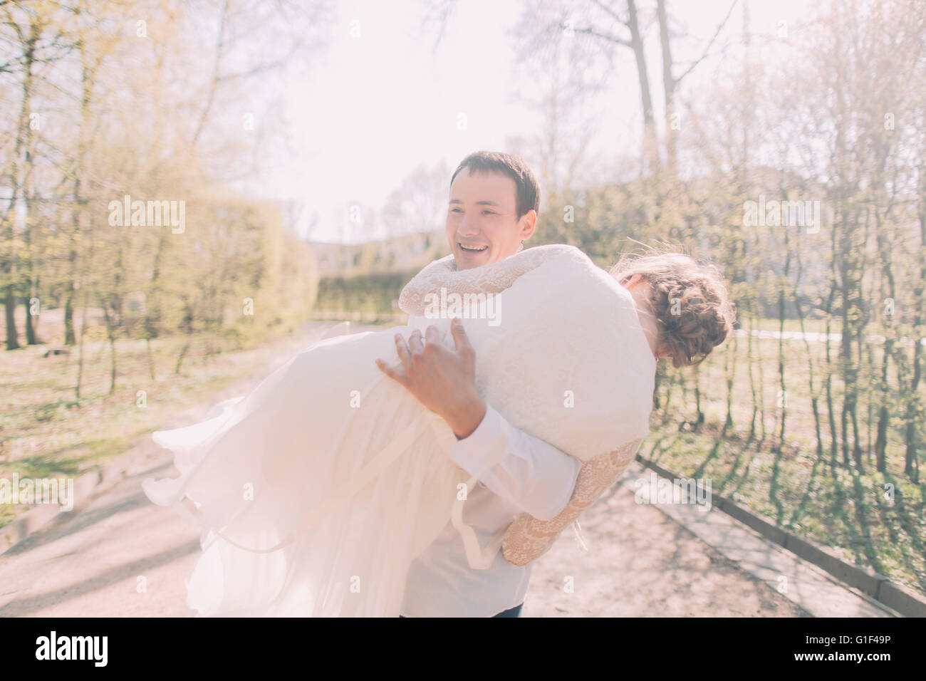 Groom carrying bride in arms hi-res stock photography and images - Alamy