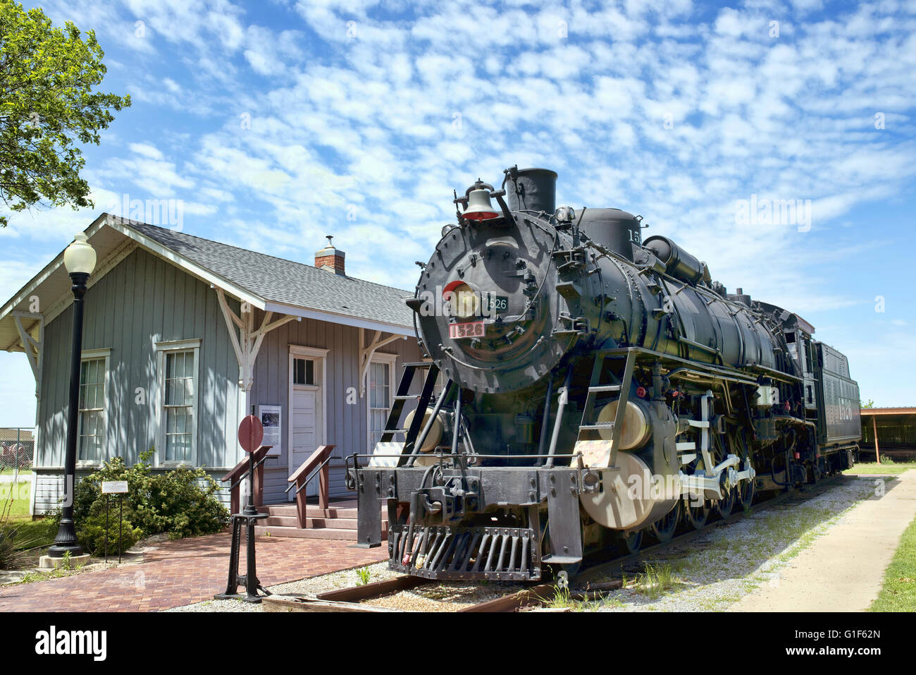 Old railroad steam engine by train station Stock Photo - Alamy