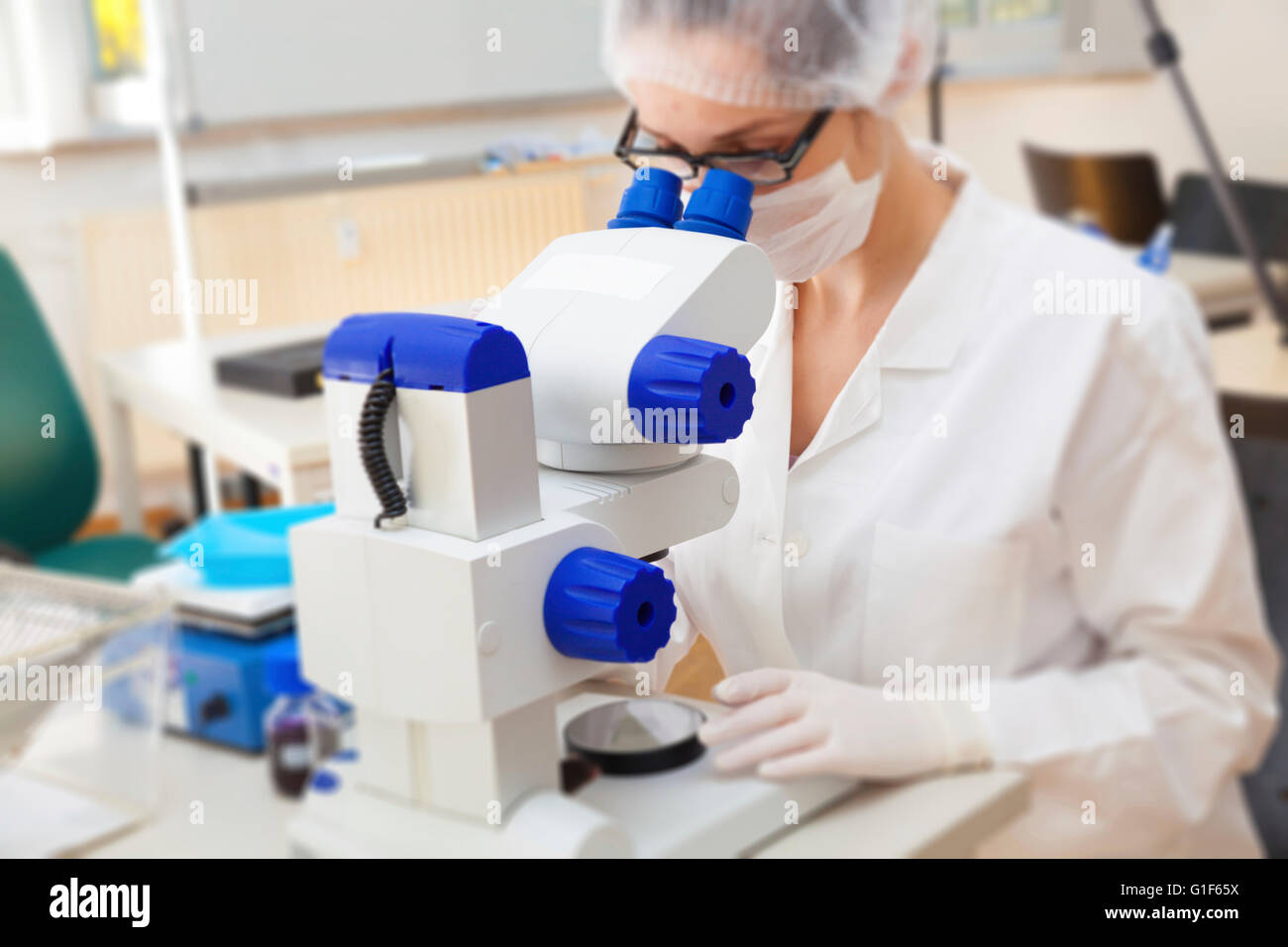 MODEL RELEASED. Lab technician using microscope Stock Photo - Alamy