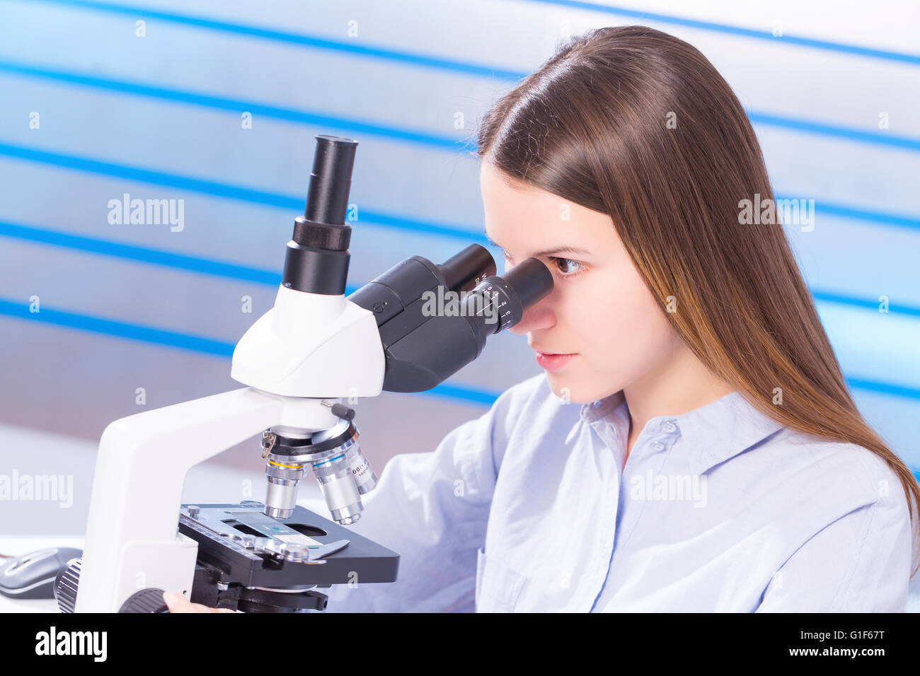 MODEL RELEASED. Female lab technician using a microscope Stock Photo ...