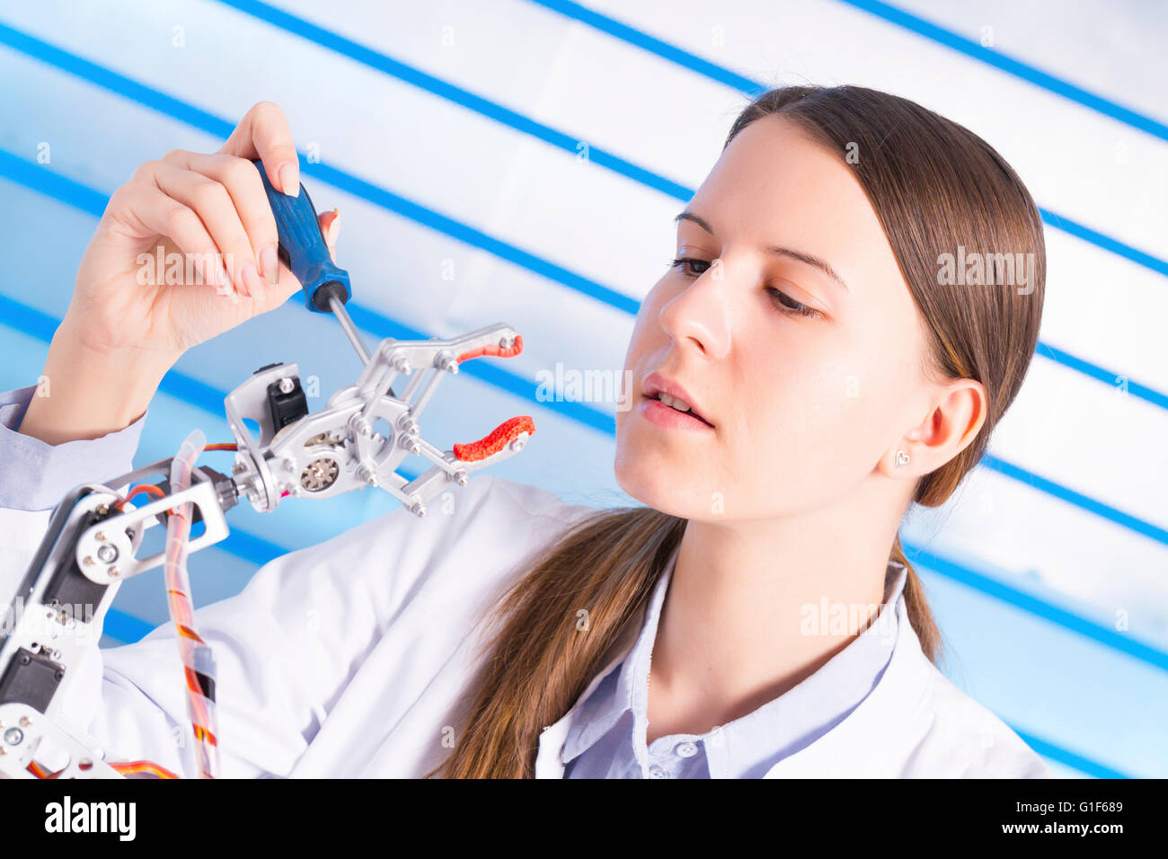 MODEL RELEASED. Female electrical engineer working on robotic arm Stock ...