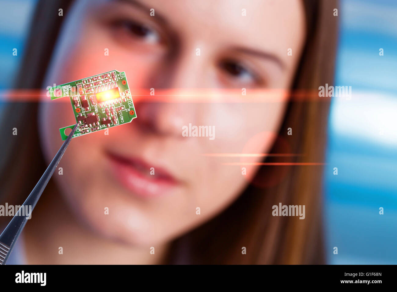 MODEL RELEASED. Female electrical engineer holding micro chip in ...