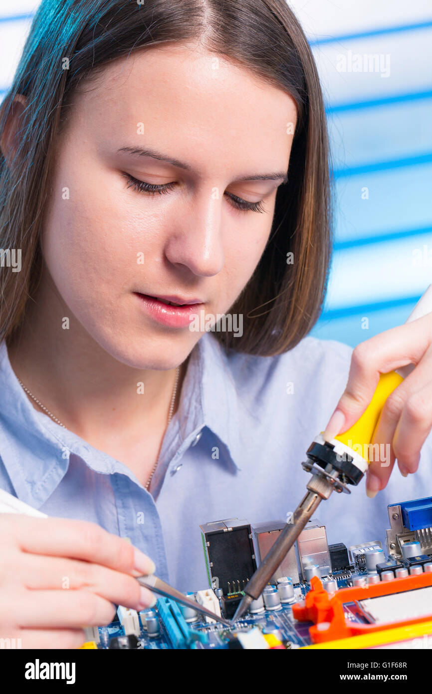 MODEL RELEASED. Female electrical engineer working on circuit board ...