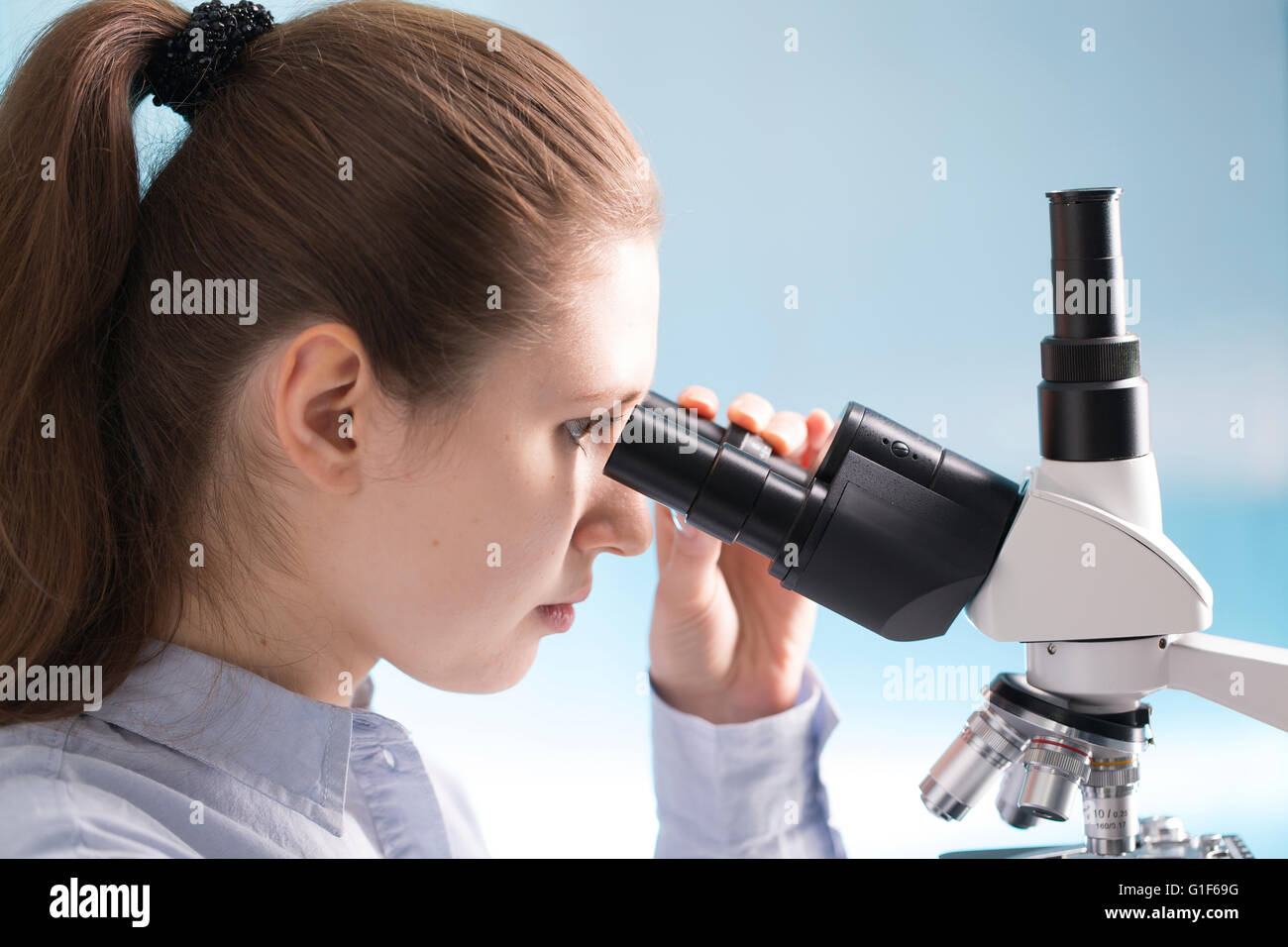 MODEL RELEASED. Female lab technician using microscope Stock Photo - Alamy