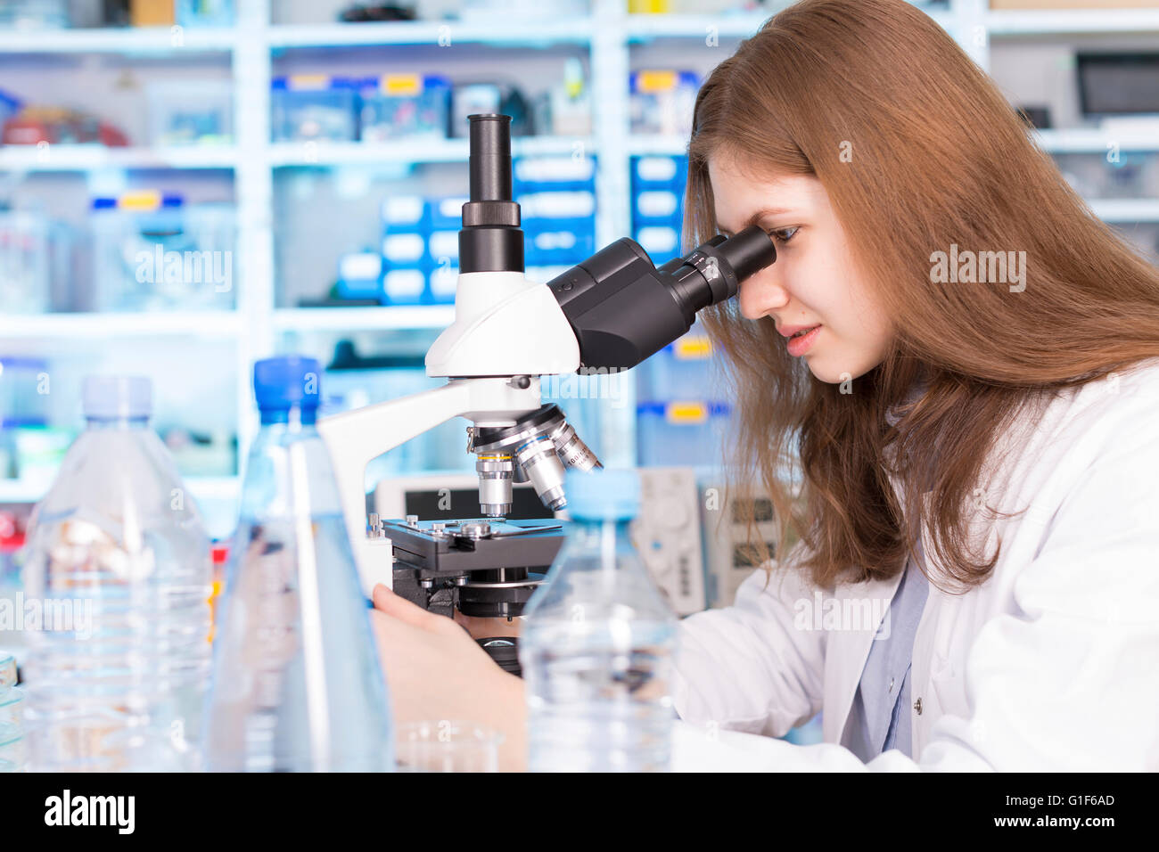 MODEL RELEASED. Female lab technician using microscope Stock Photo - Alamy