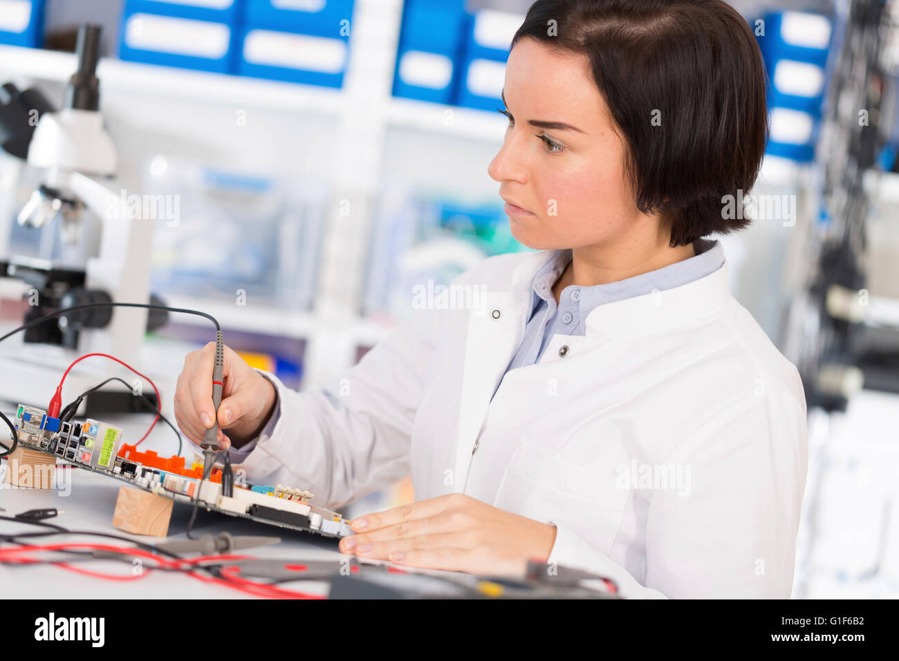 MODEL RELEASED. Female electrical engineer working on a circuit board ...