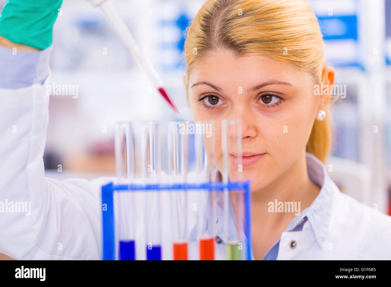 MODEL RELEASED. Female scientist using a pipette with test tubes Stock ...