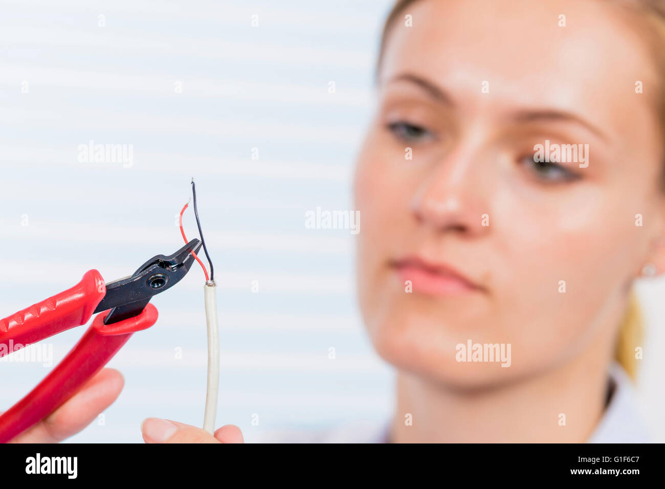 MODEL RELEASED. Female technician using pair of pliers with wires Stock ...