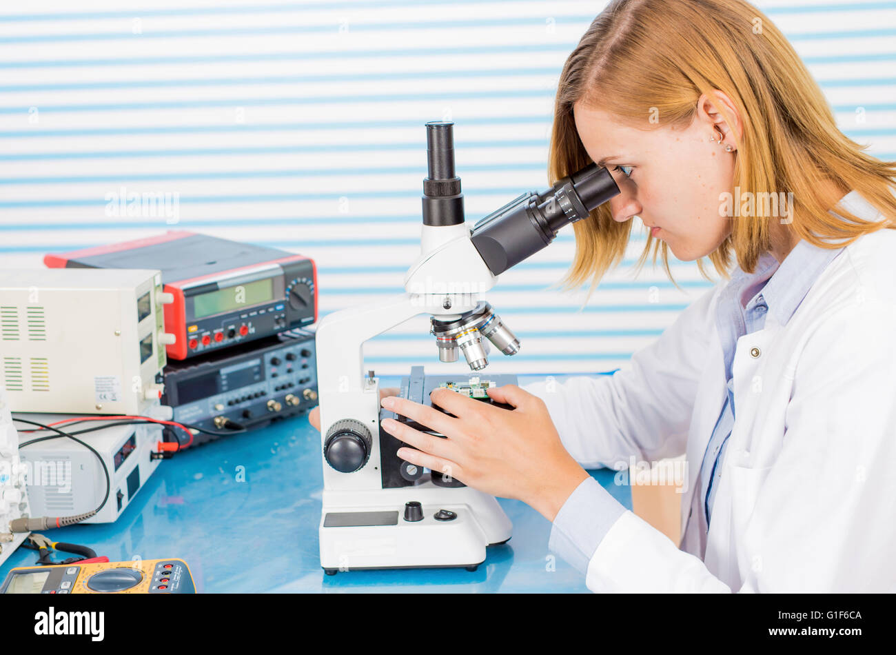 MODEL RELEASED. Female technician with microscope in the laboratory ...