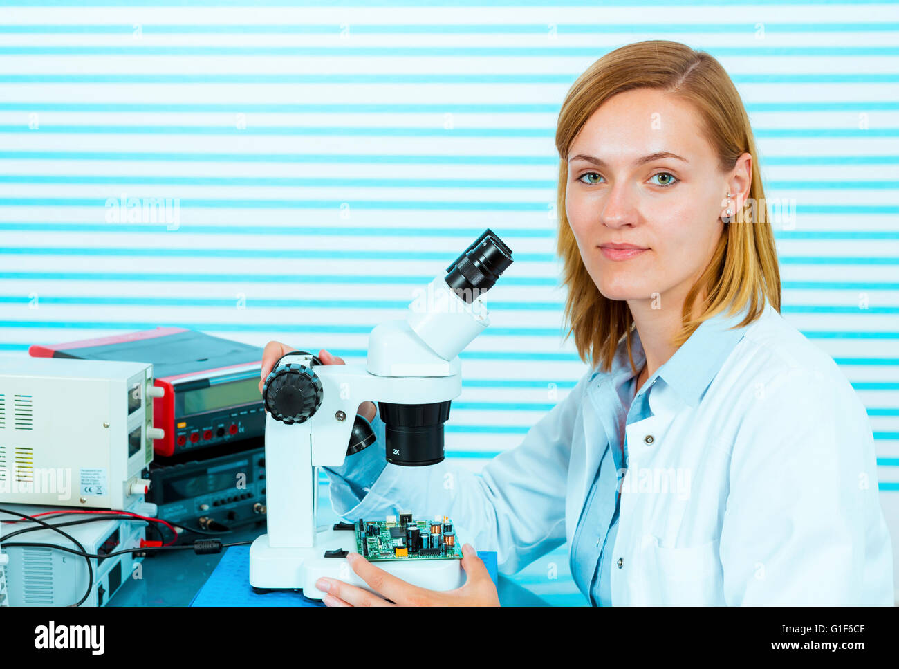 MODEL RELEASED. Female technician with microscope in the laboratory ...