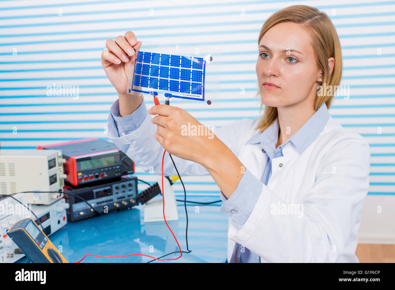 MODEL RELEASED. Female technician holding thin film solar cells Stock ...
