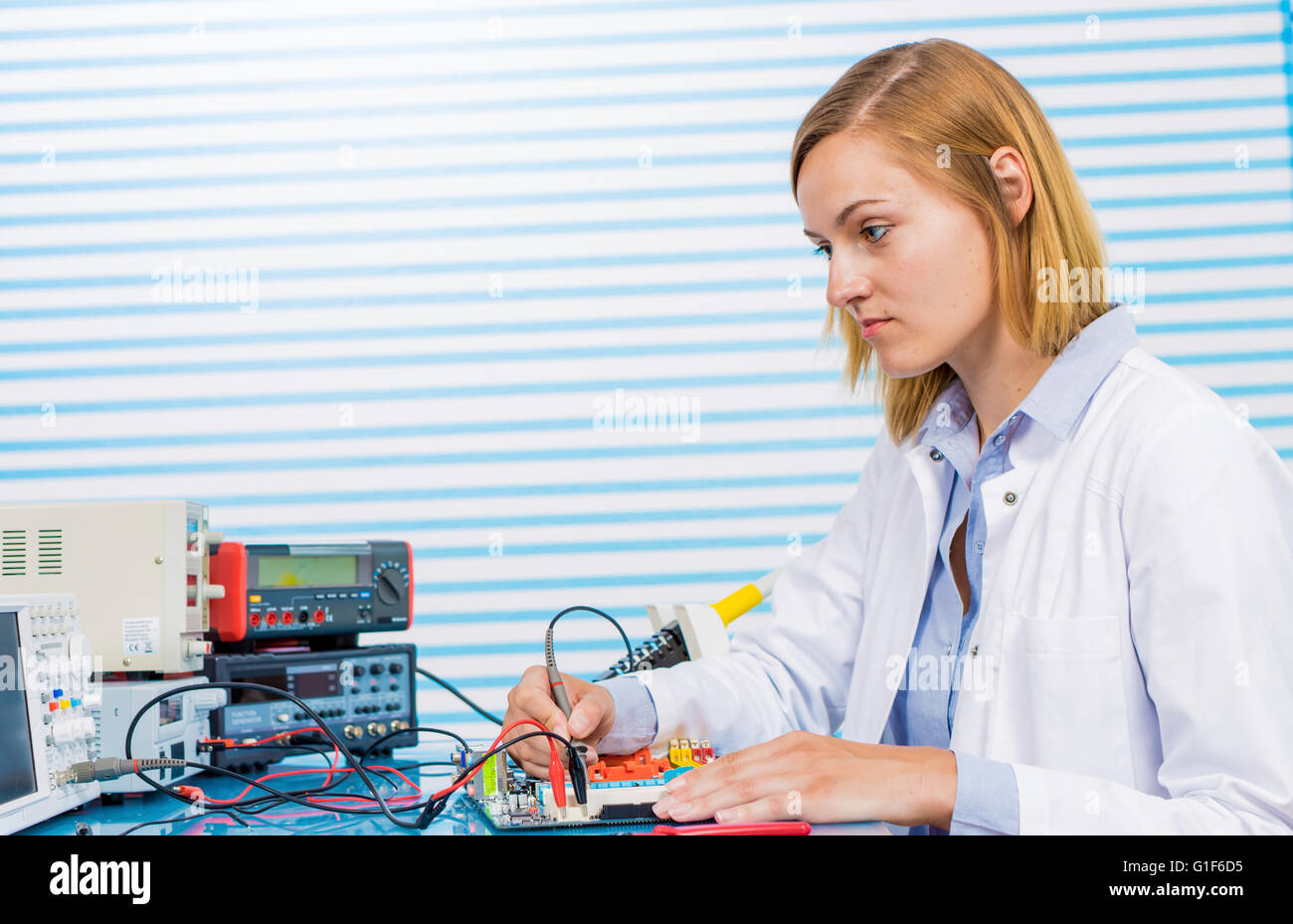 MODEL RELEASED. Female electrical engineer working in the laboratory ...
