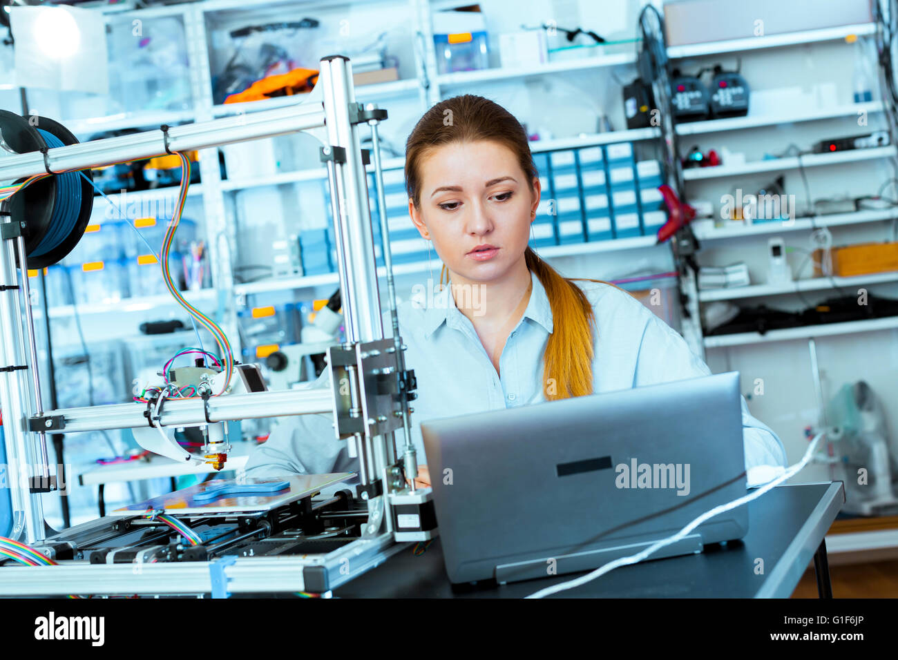 MODEL RELEASED. Young woman using a 3d printer Stock Photo - Alamy