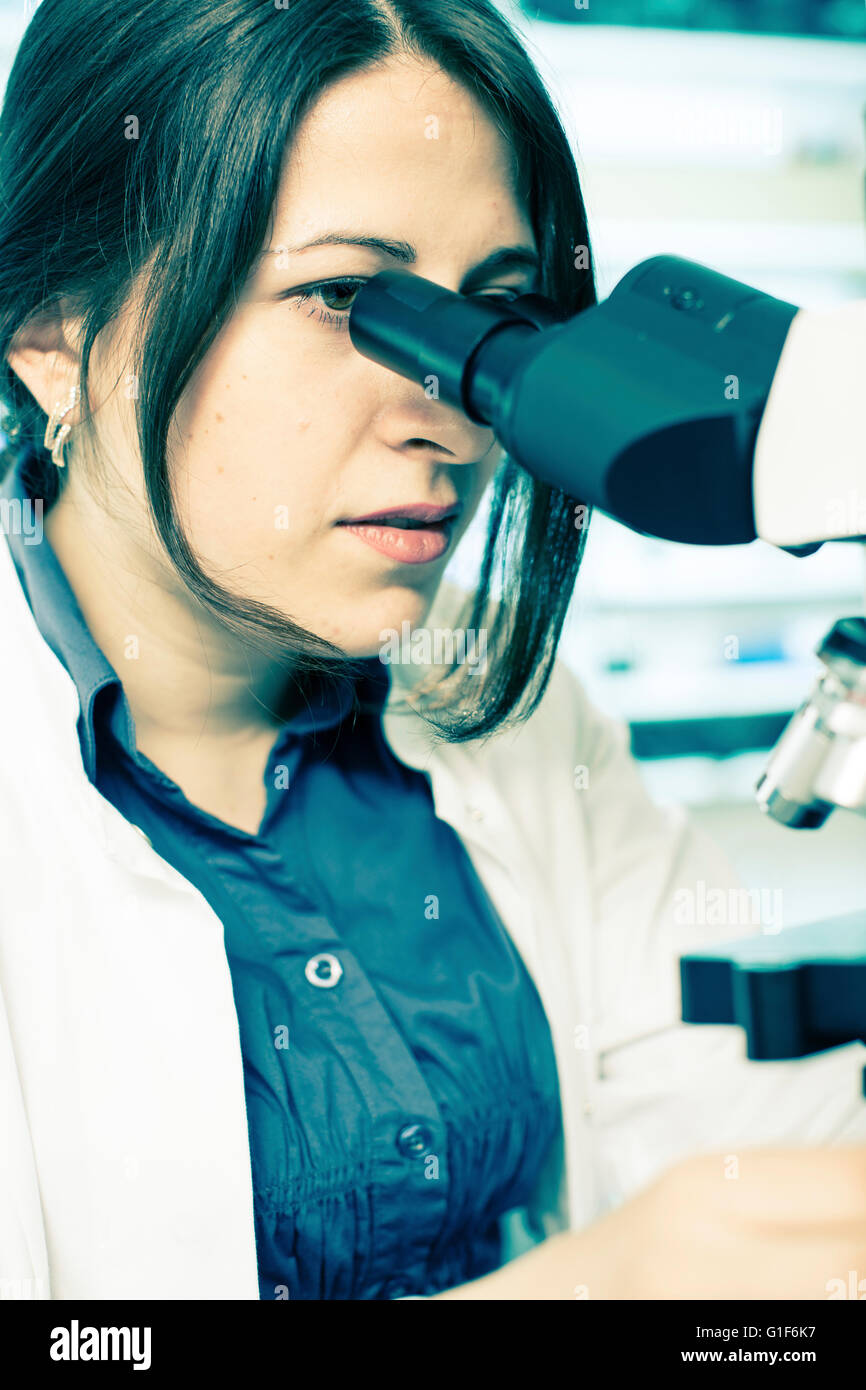 MODEL RELEASED. Female laboratory technician using a microscope Stock ...