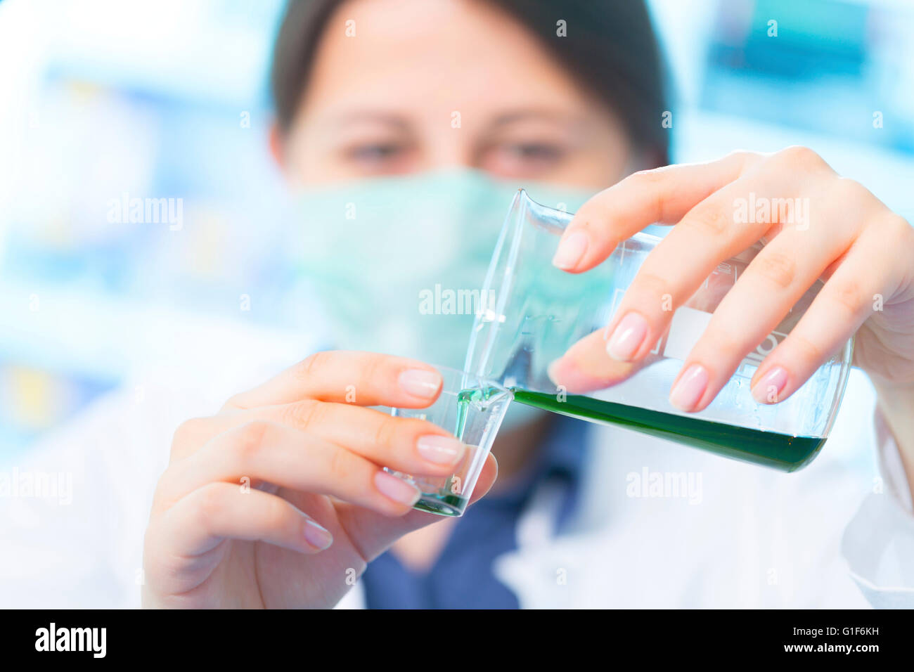 Scientist pouring liquid into beaker hi-res stock photography and ...