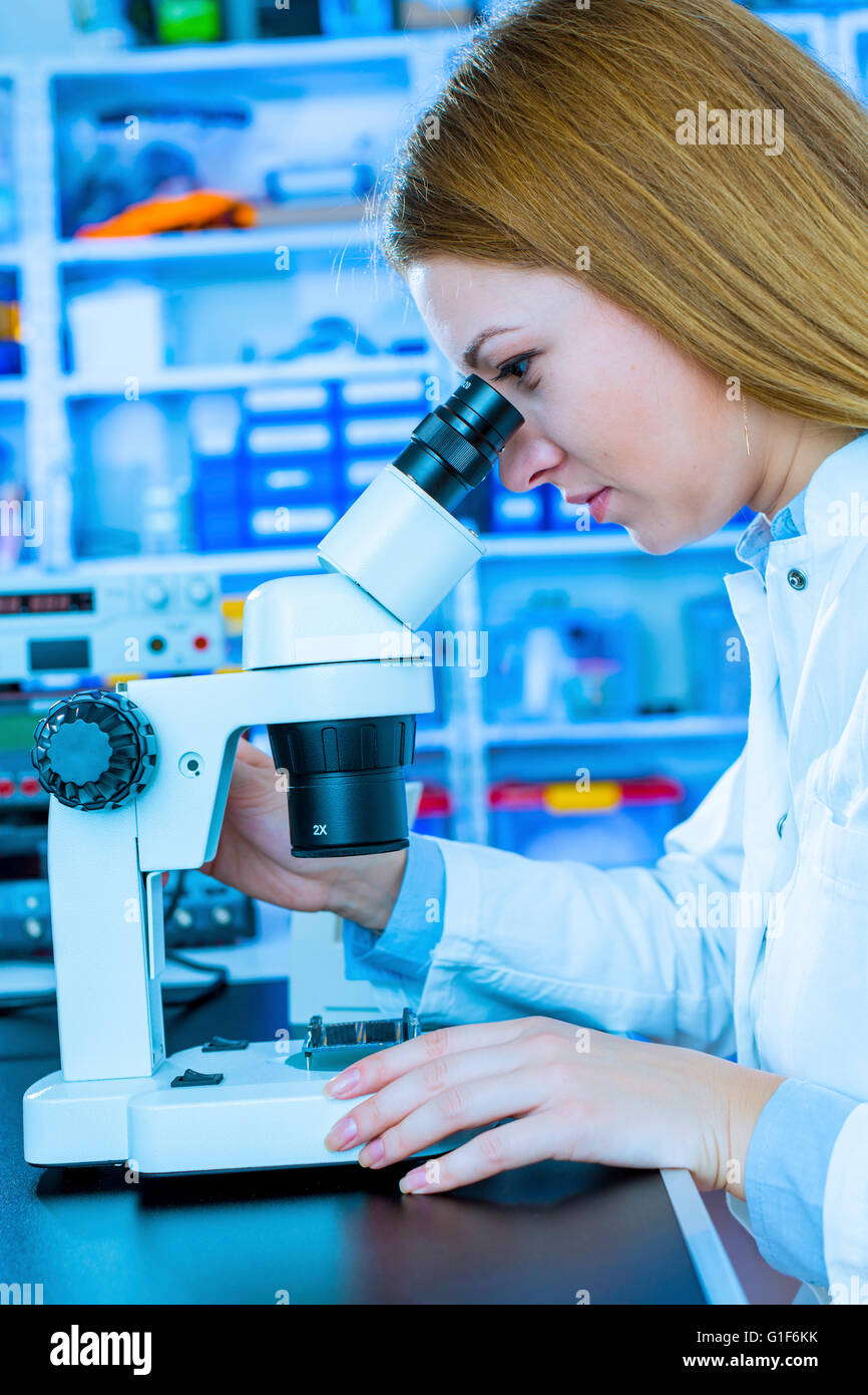 MODEL RELEASED. Female laboratory technician using a microscope Stock ...