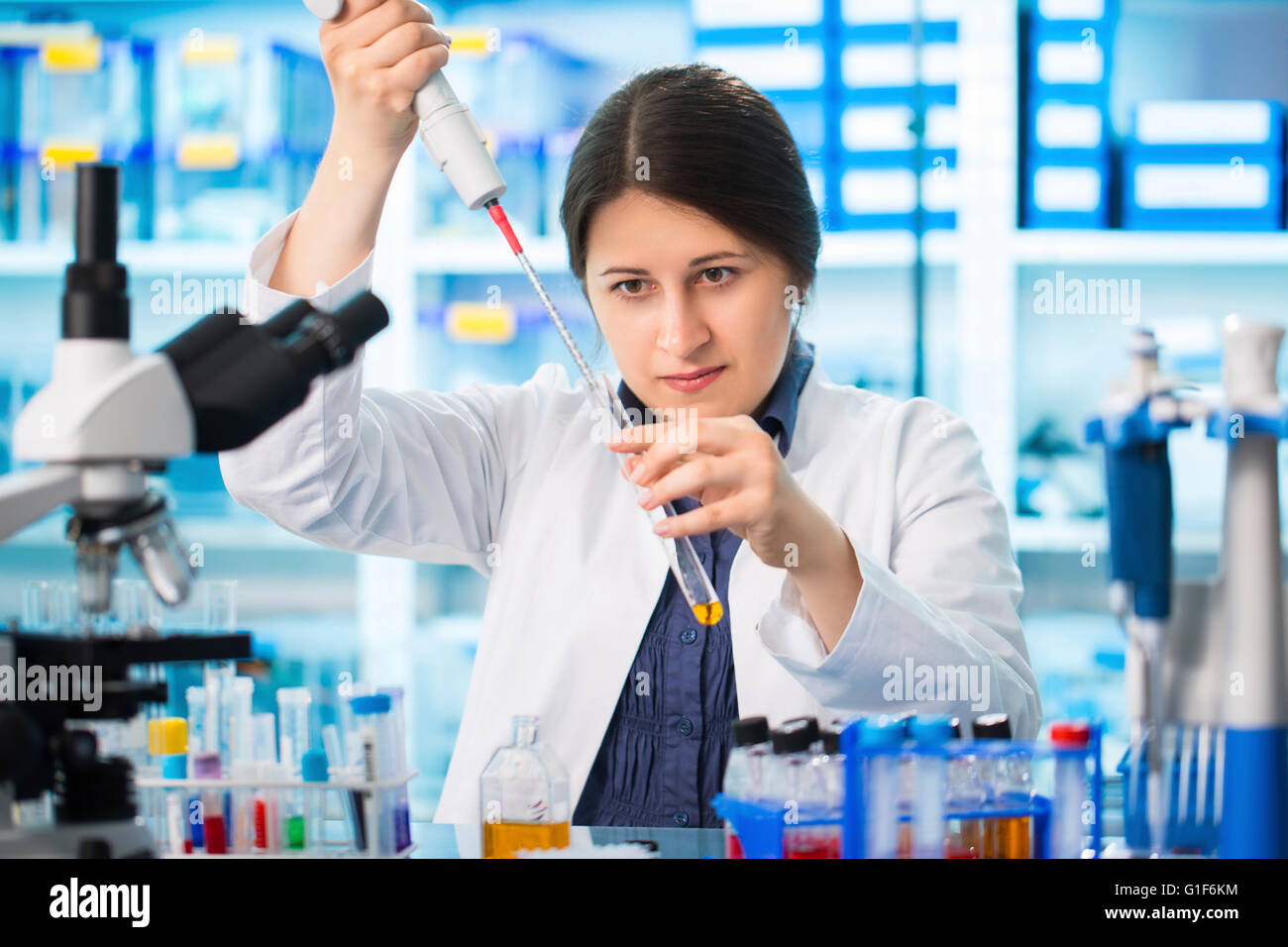 MODEL RELEASED. Female laboratory technician using a pipette Stock ...