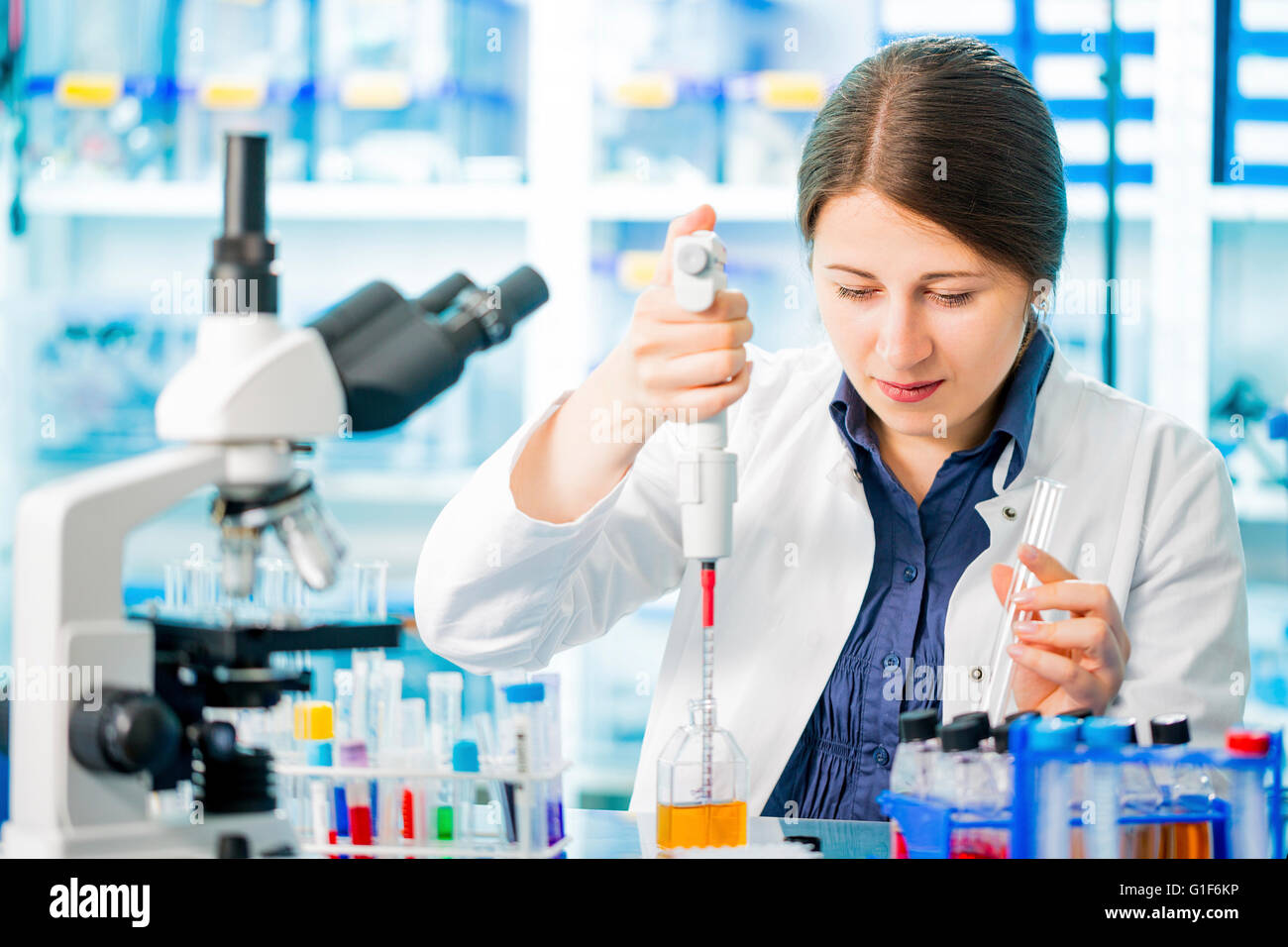 MODEL RELEASED. Female laboratory technician using a pipette Stock ...