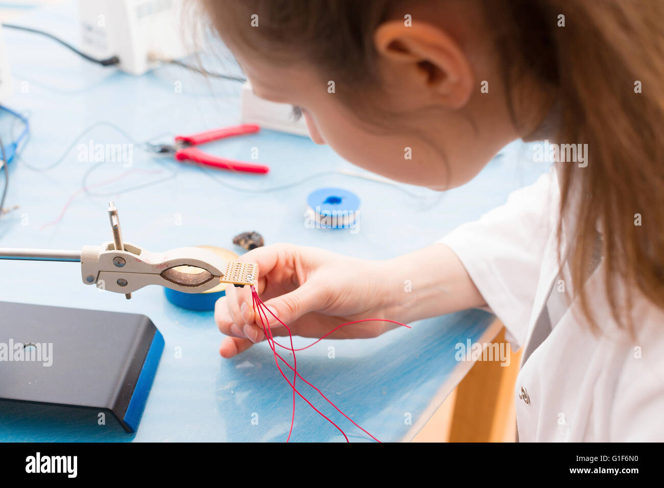 MODEL RELEASED. Female technician assembling an electrical sensor Stock ...