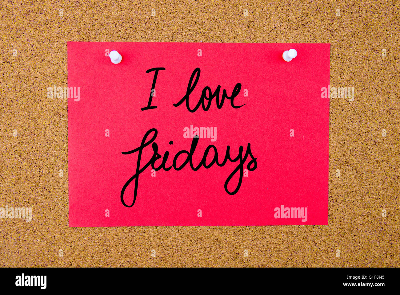 Red paper note with handwritten text I Love Fridays pinned on cork ...
