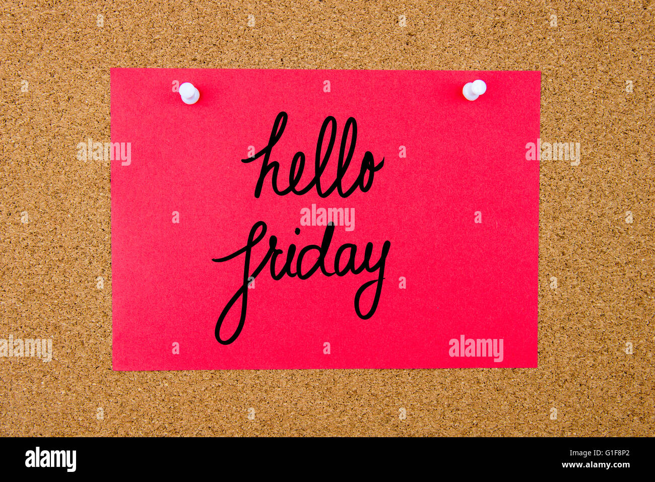 Red paper note with handwritten text Hello Friday pinned on cork board ...