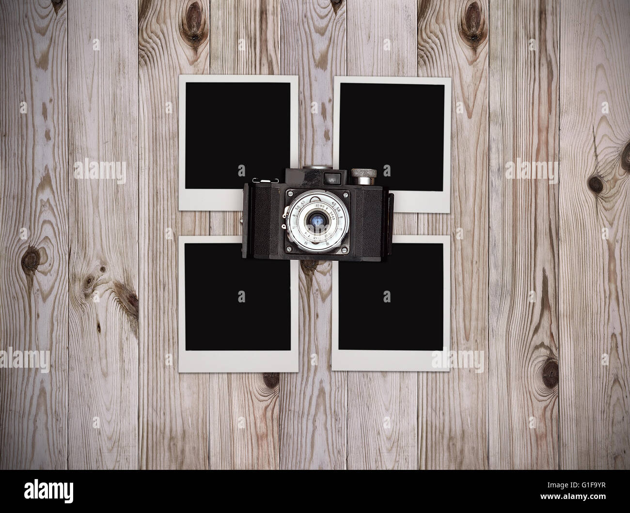 Vintage camera with four blank photo on wooden table Stock Photo - Alamy