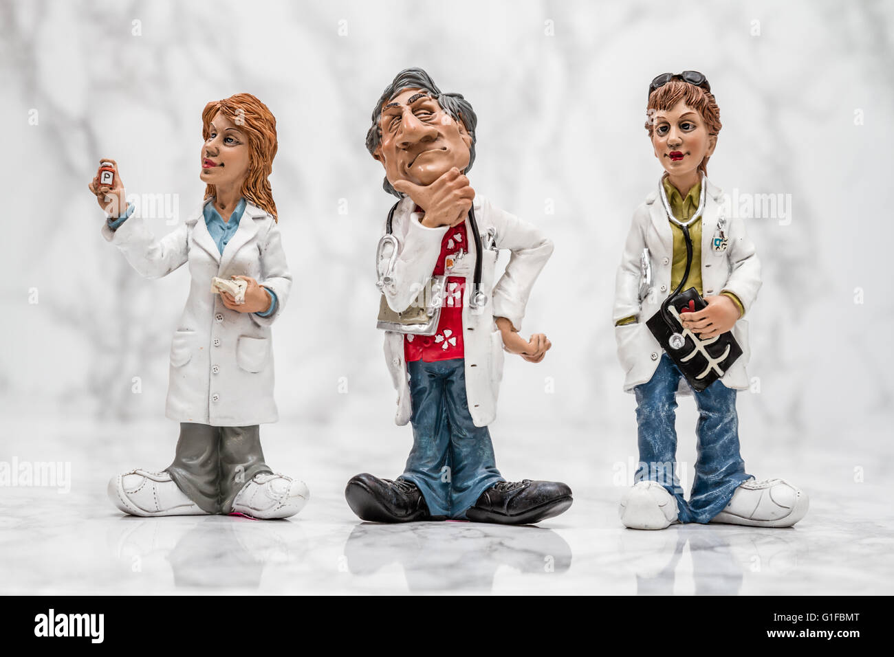 Collection of statuettes of different professions on white marble ...