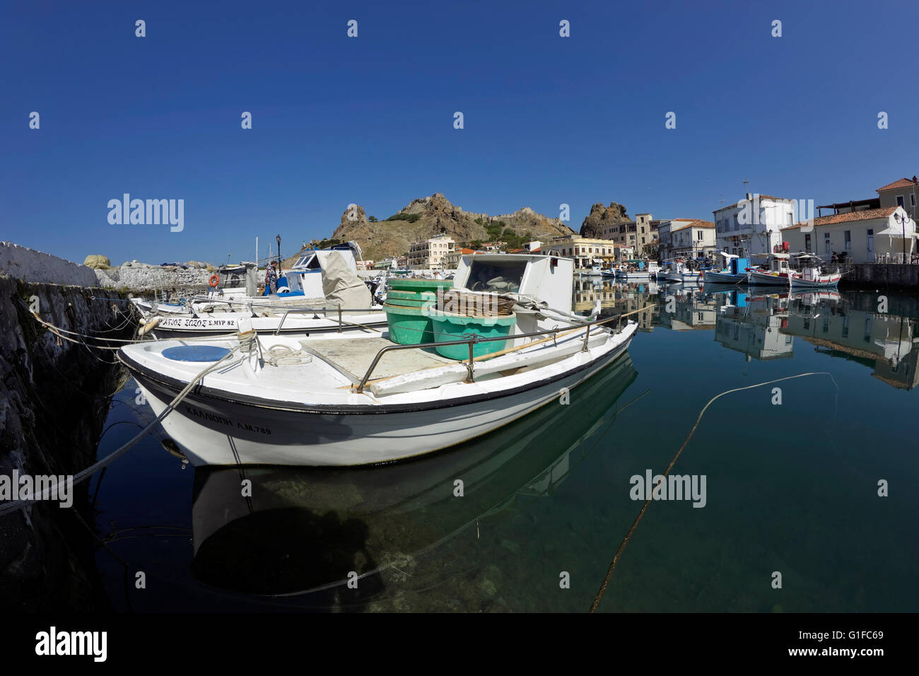 Traditional fishing boats floating in Myrina's harbor limpid sea waters ...