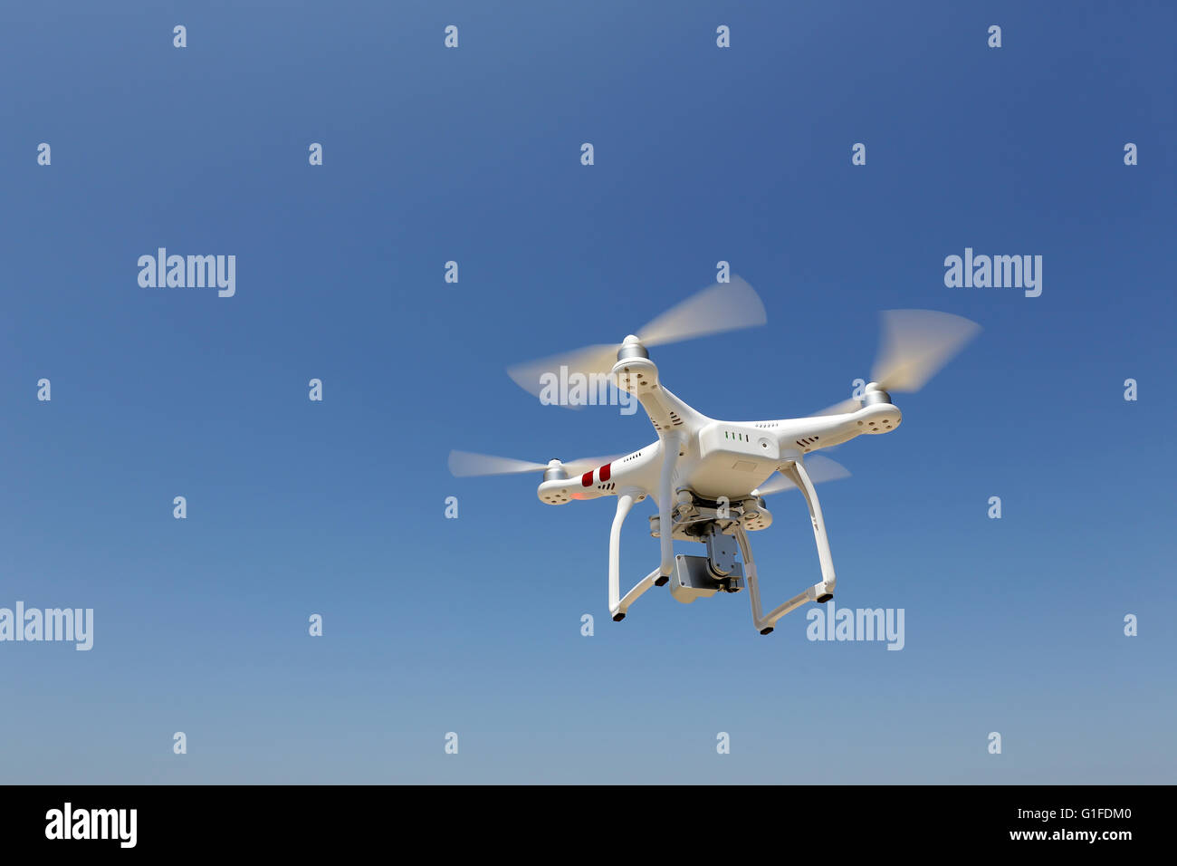 White drone quad copter with flying in the clear blue sky Stock Photo ...