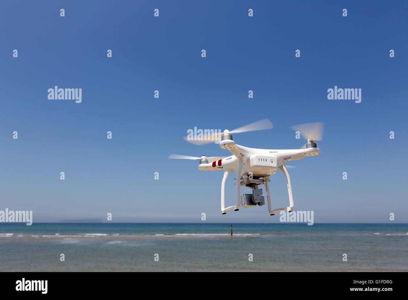 White drone quad copter with flying in the clear blue sky Stock Photo ...